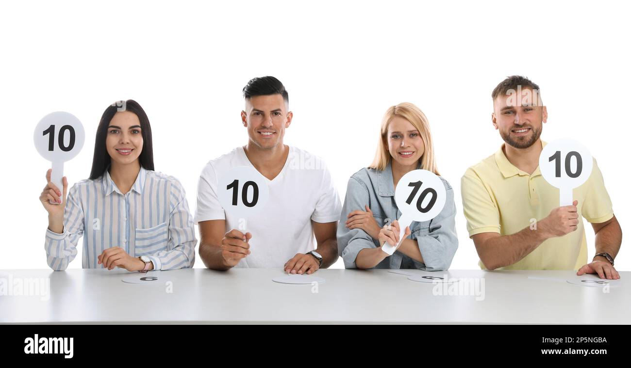 Panel of judges holding signs with highest score at table on white ...