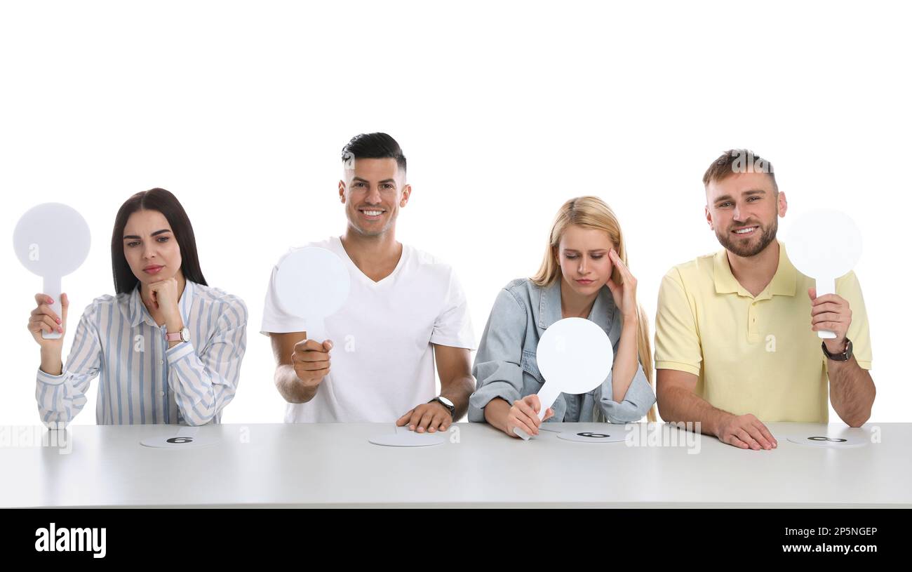 Panel of judges with different emotions holding blank signs at table on ...