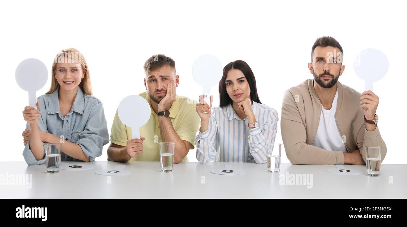 Panel of judges with different emotions holding blank signs at table on ...
