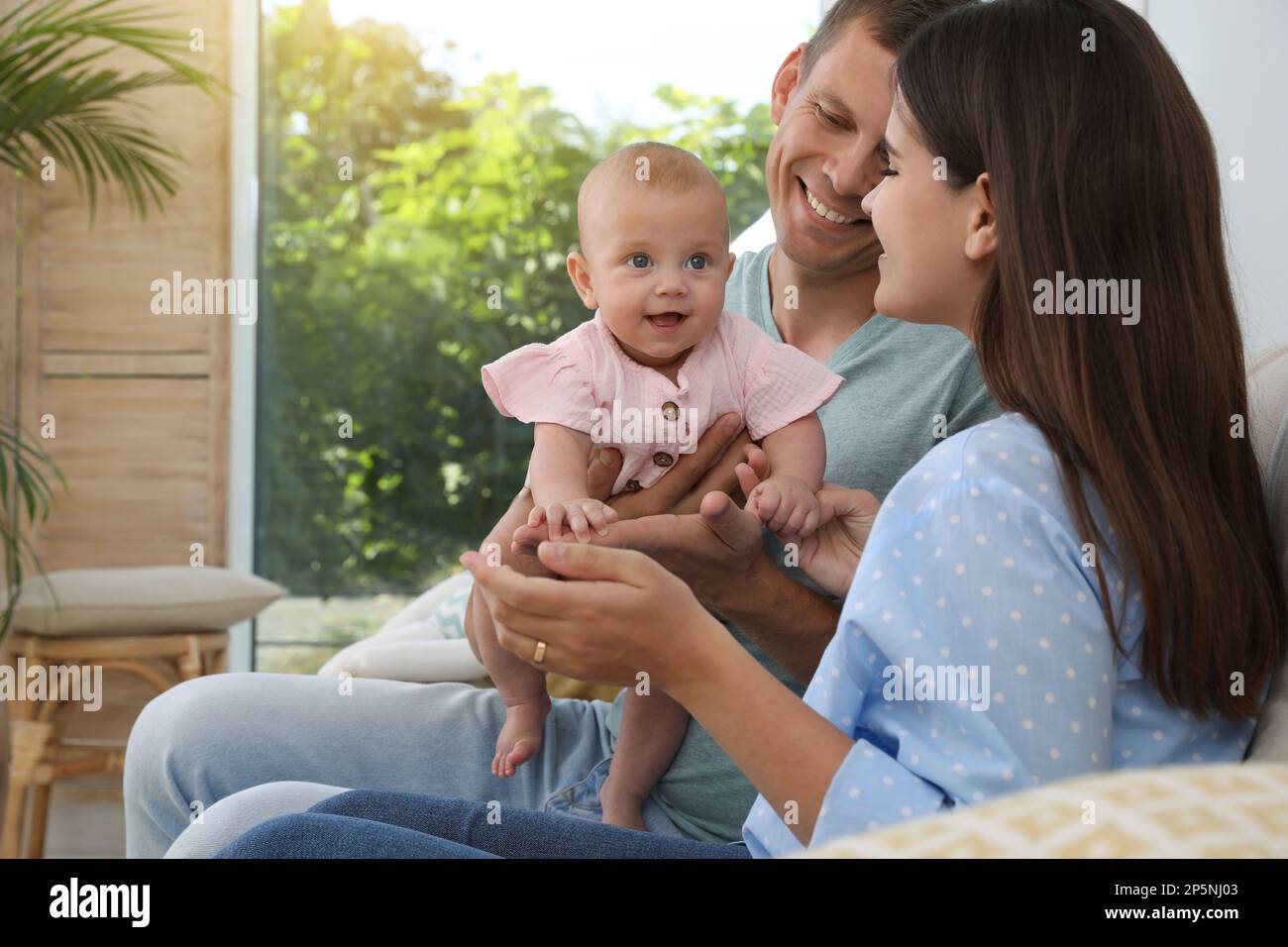 Happy family with their cute baby in living room at home Stock Photo ...