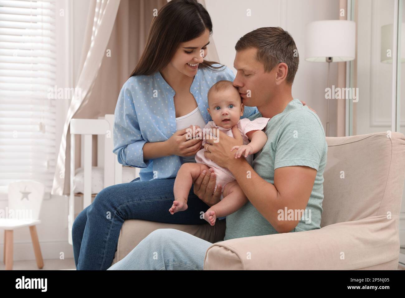 Happy family with their cute baby at home Stock Photo - Alamy