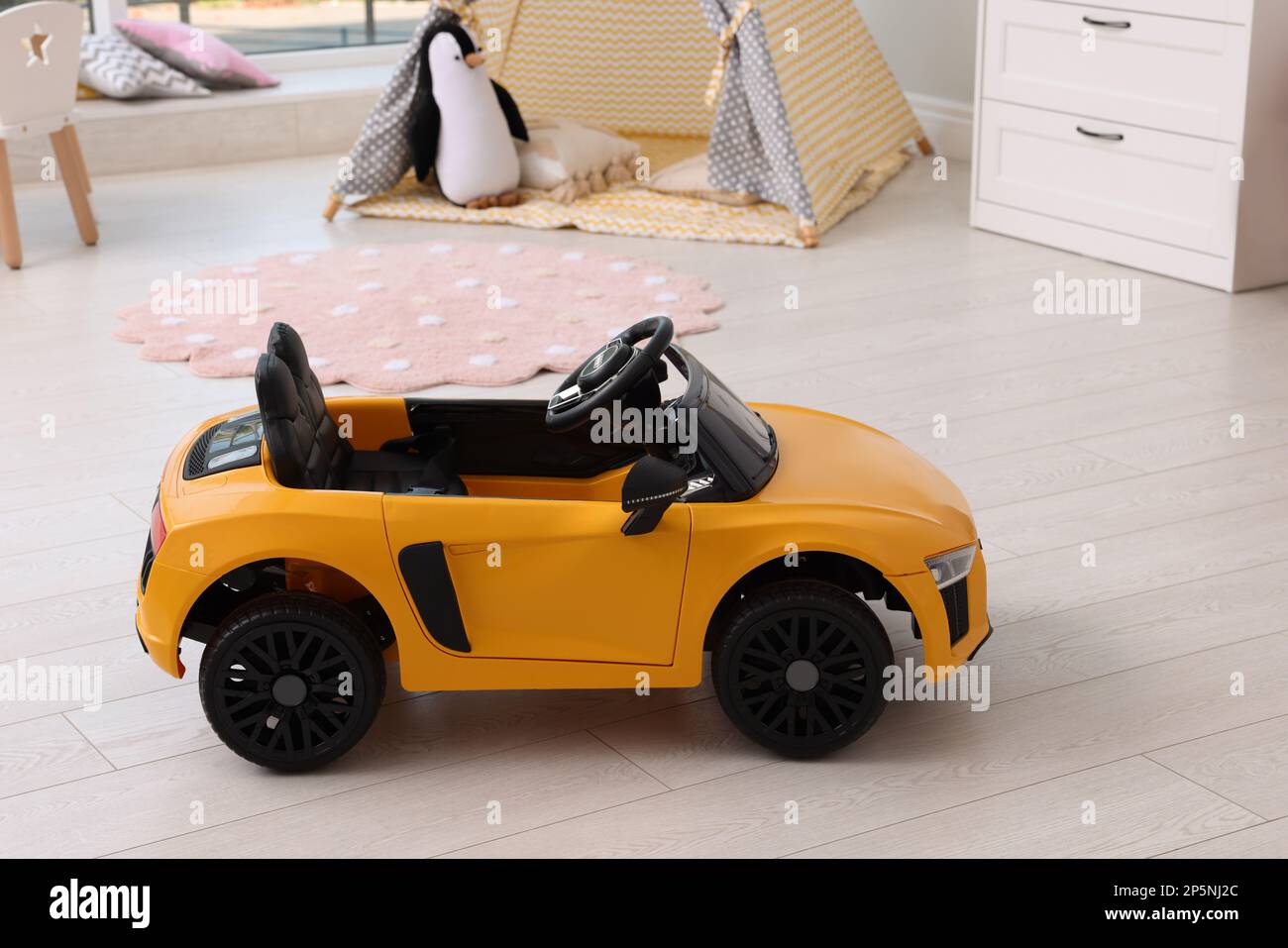 Yellow car in room at home. Child's toy Stock Photo - Alamy