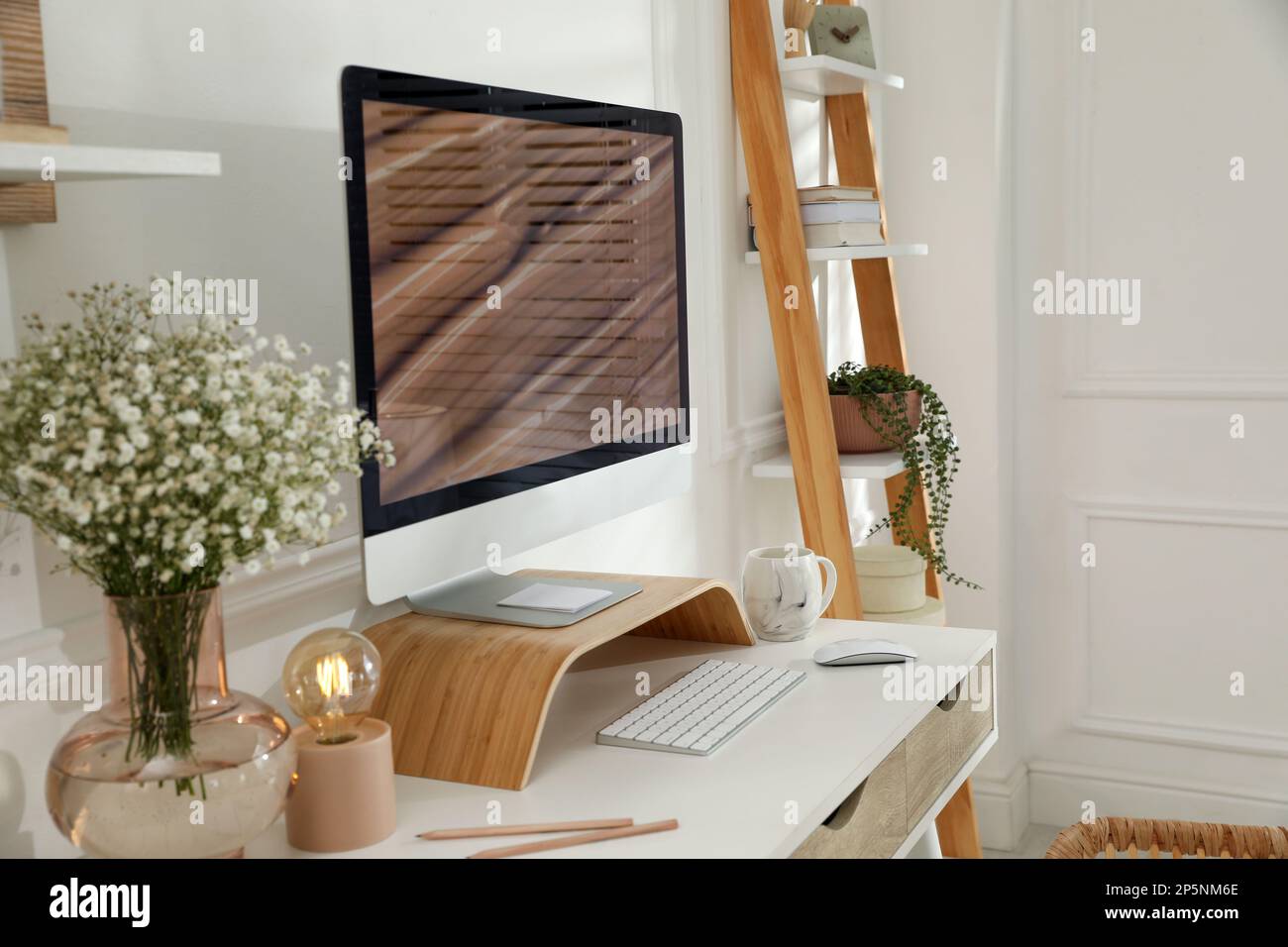 Comfortable workplace with modern computer and beautiful flowers in ...