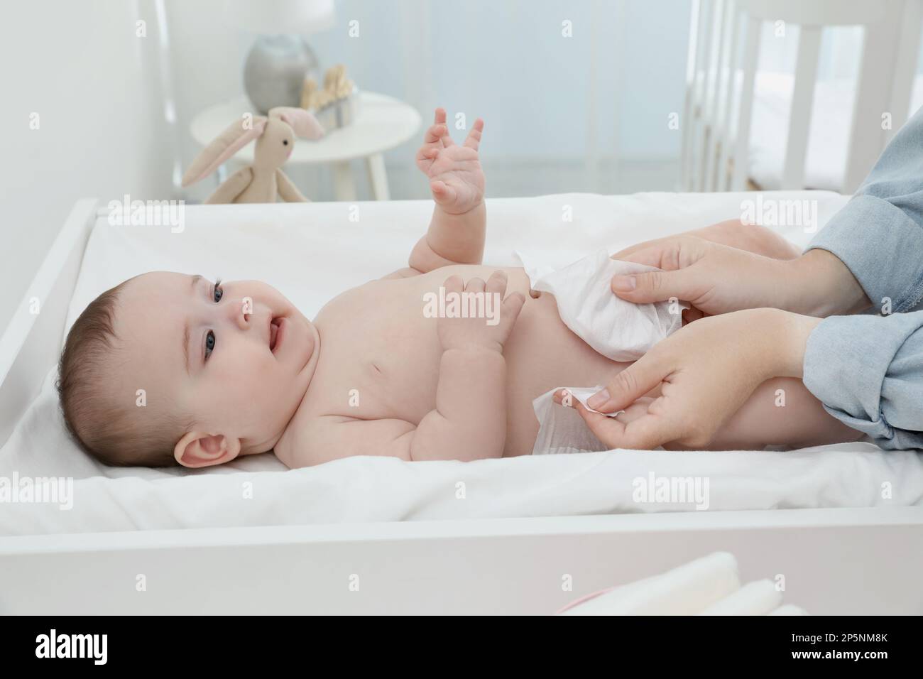Mother changing baby's diaper on table at home Stock Photo - Alamy