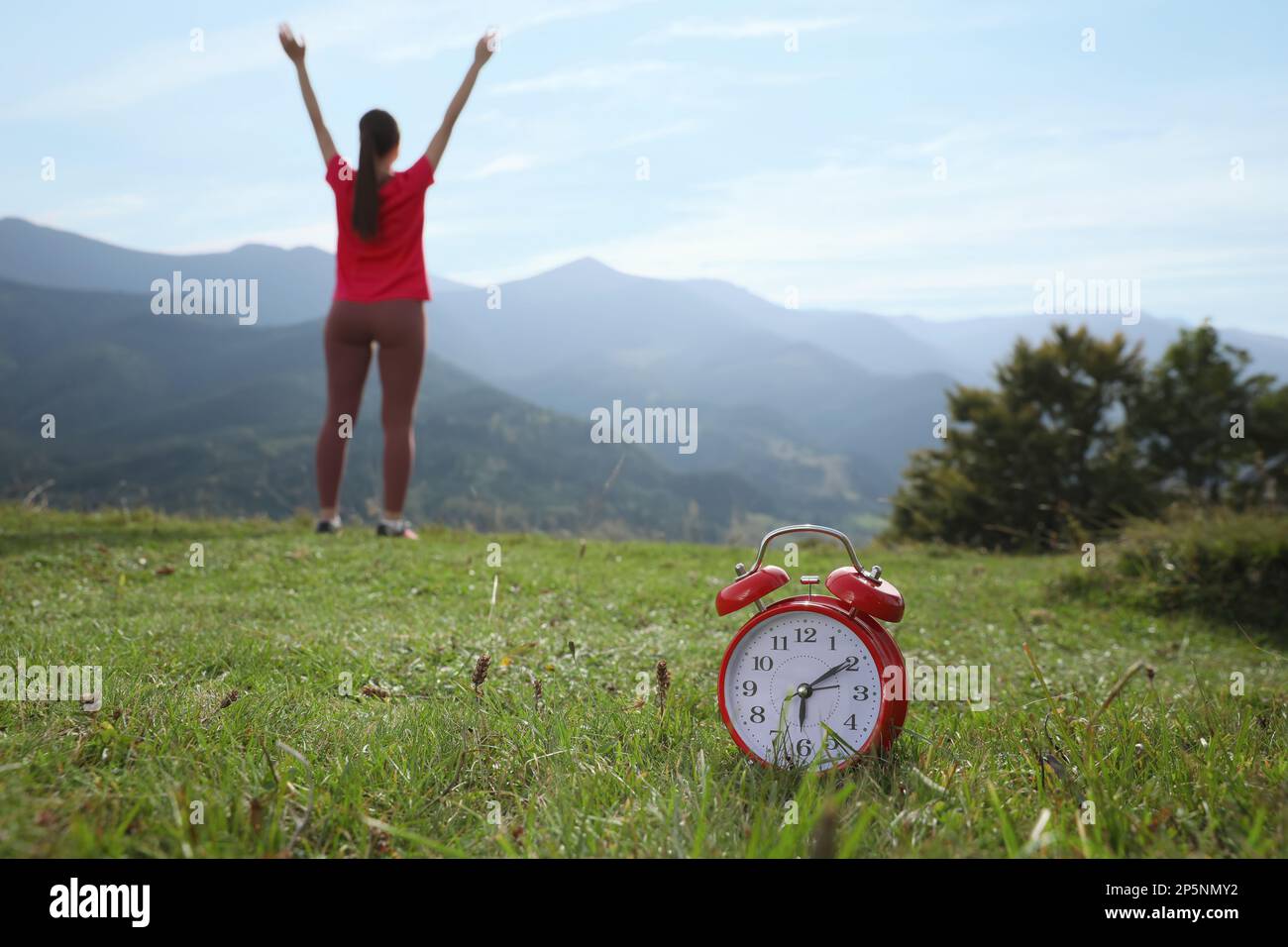 Woman doing morning exercise in mountains, focus on alarm clock Stock ...