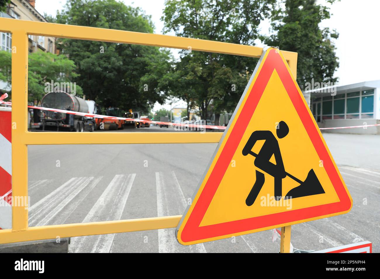 Barricade with road construction sign on city street, closeup. Repair ...