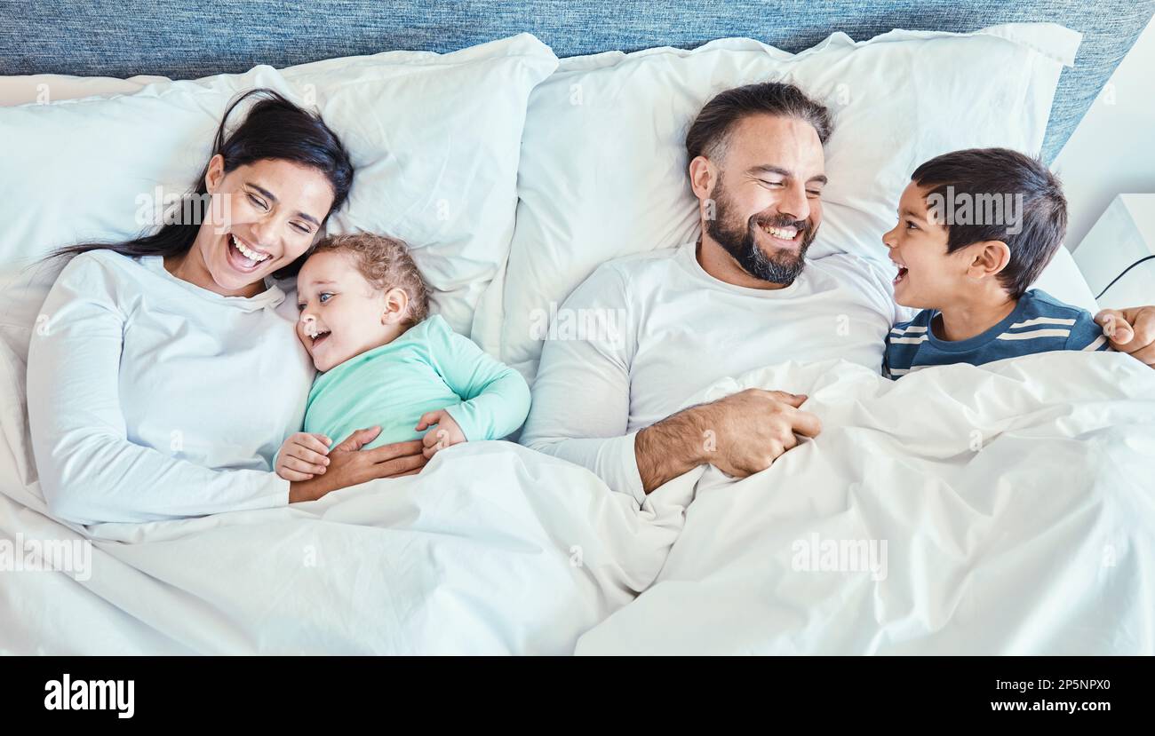 Waking up, bed and family relax, happy and bond while resting, talking ...