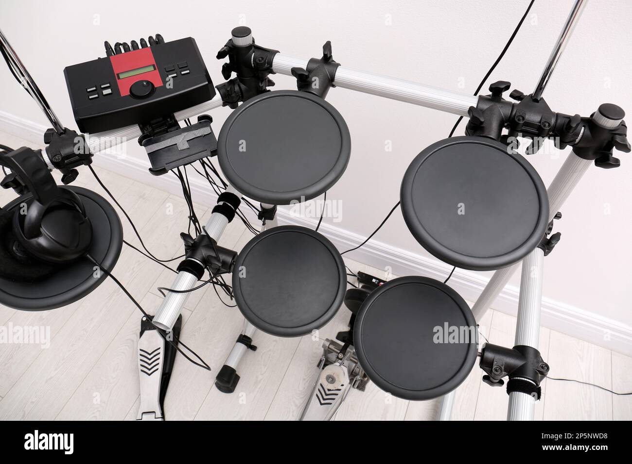 Modern electronic drum kit near white wall indoors, above view. Musical ...