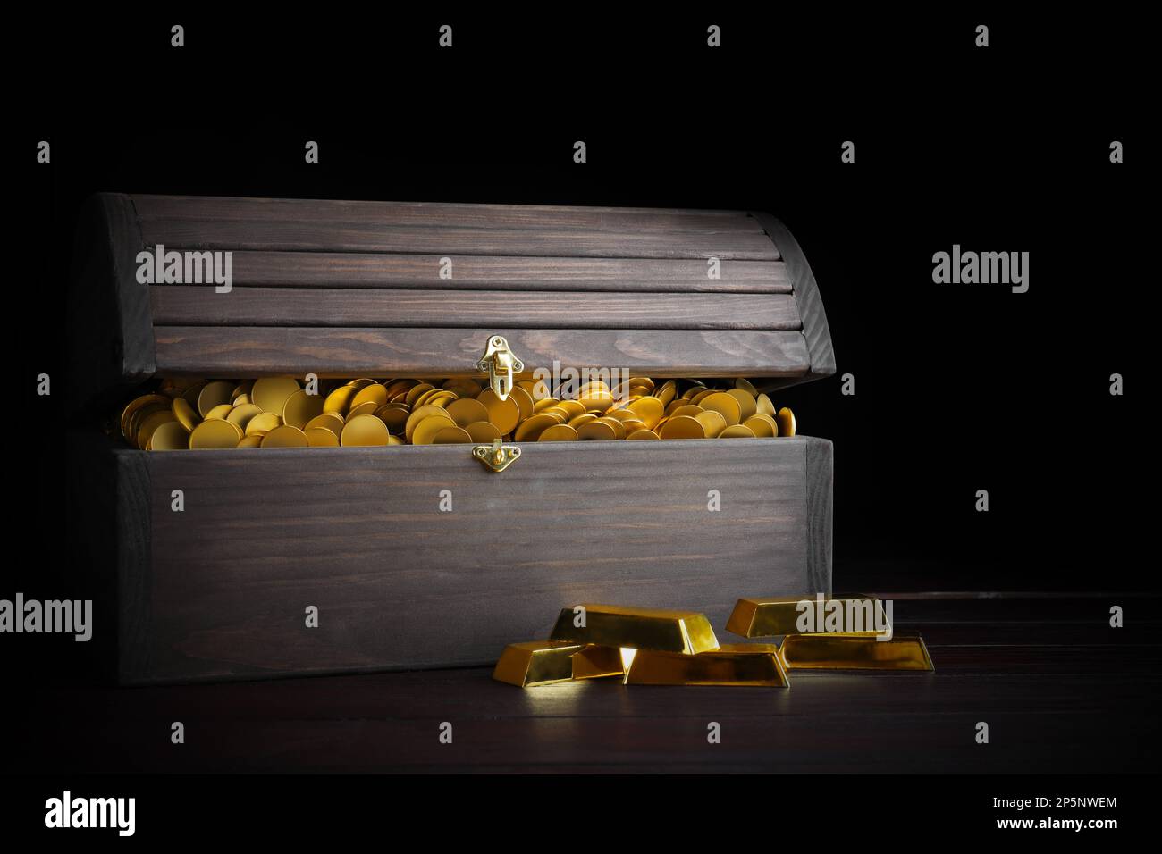 Open treasure chest with coins and gold bars on wooden table Stock ...