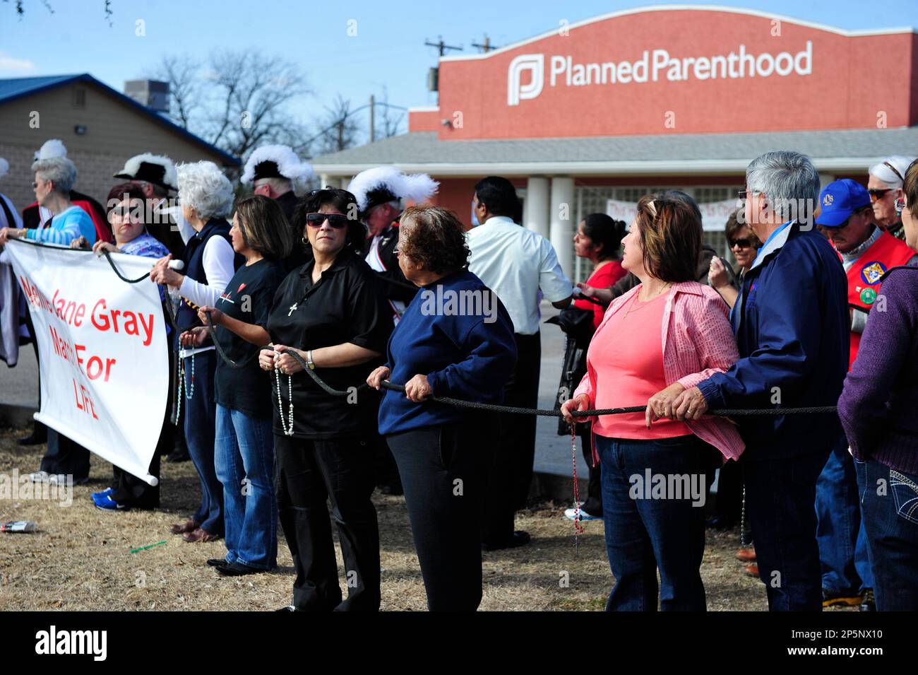 Pro-life supporters stand side-by side while holding a rosary life line ...