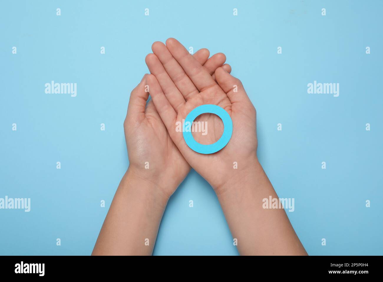 Woman showing blue paper circle as World Diabetes Day symbol on color ...