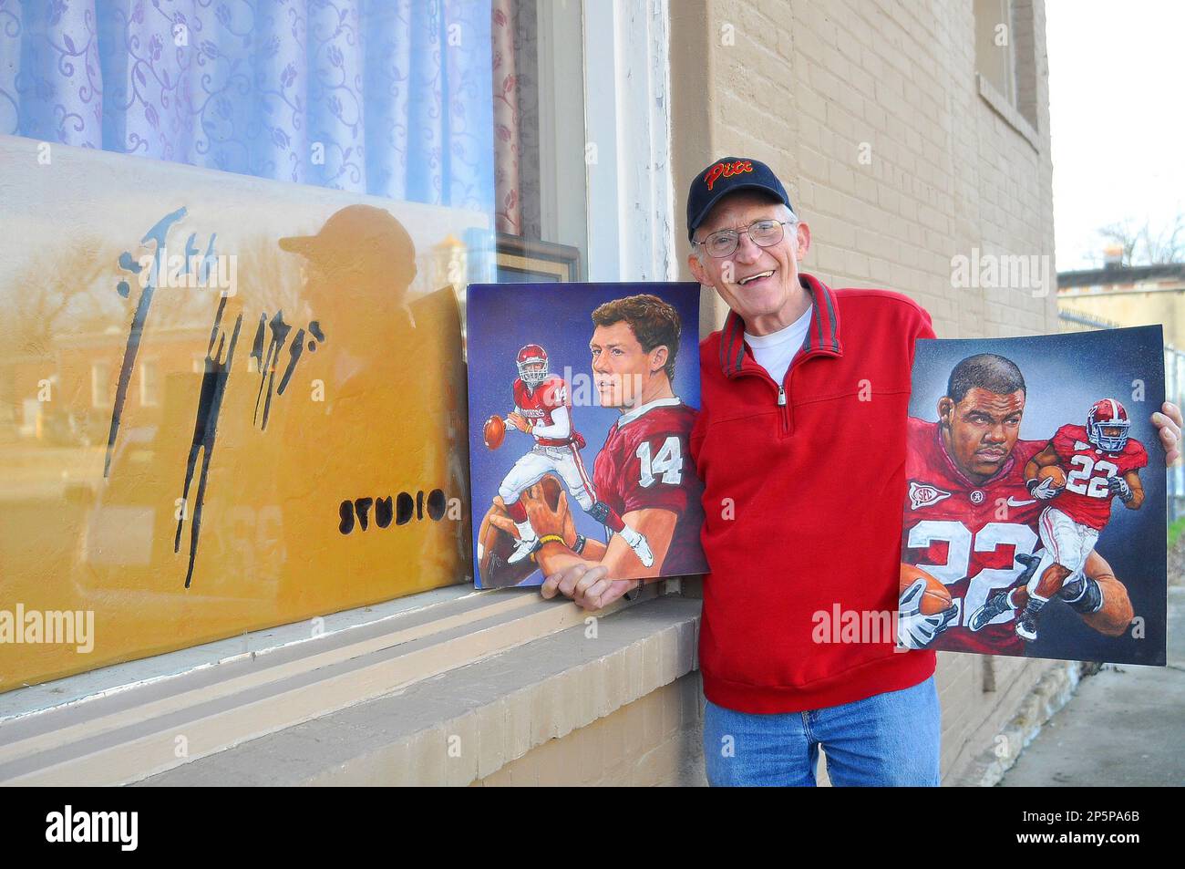Ted Watts stands outside his studio in Oswego, Kan., with his two most recent Heisman portraits ...