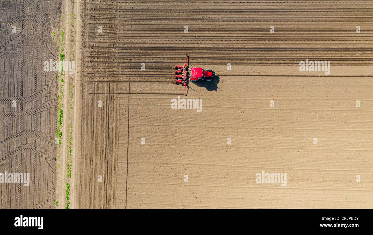 Above top view, of tractor as pulling mechanical seeder machine over ...