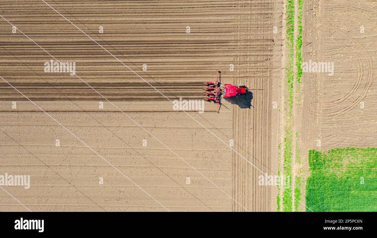 Above top view, of tractor as pulling mechanical seeder machine over ...