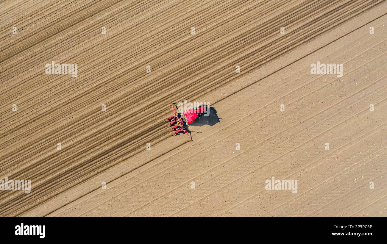 Above top view, of tractor as pulling mechanical seeder machine over ...