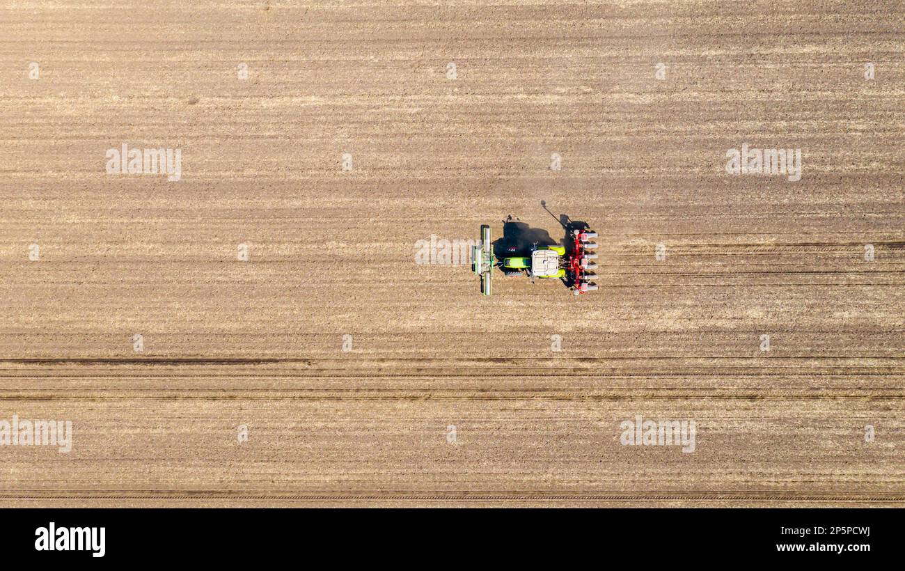 Above top view, of tractor as pulling mechanical seeder machine over ...