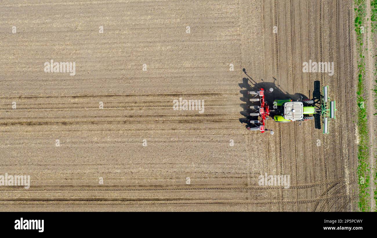 Above top view, of tractor as pulling mechanical seeder machine over ...