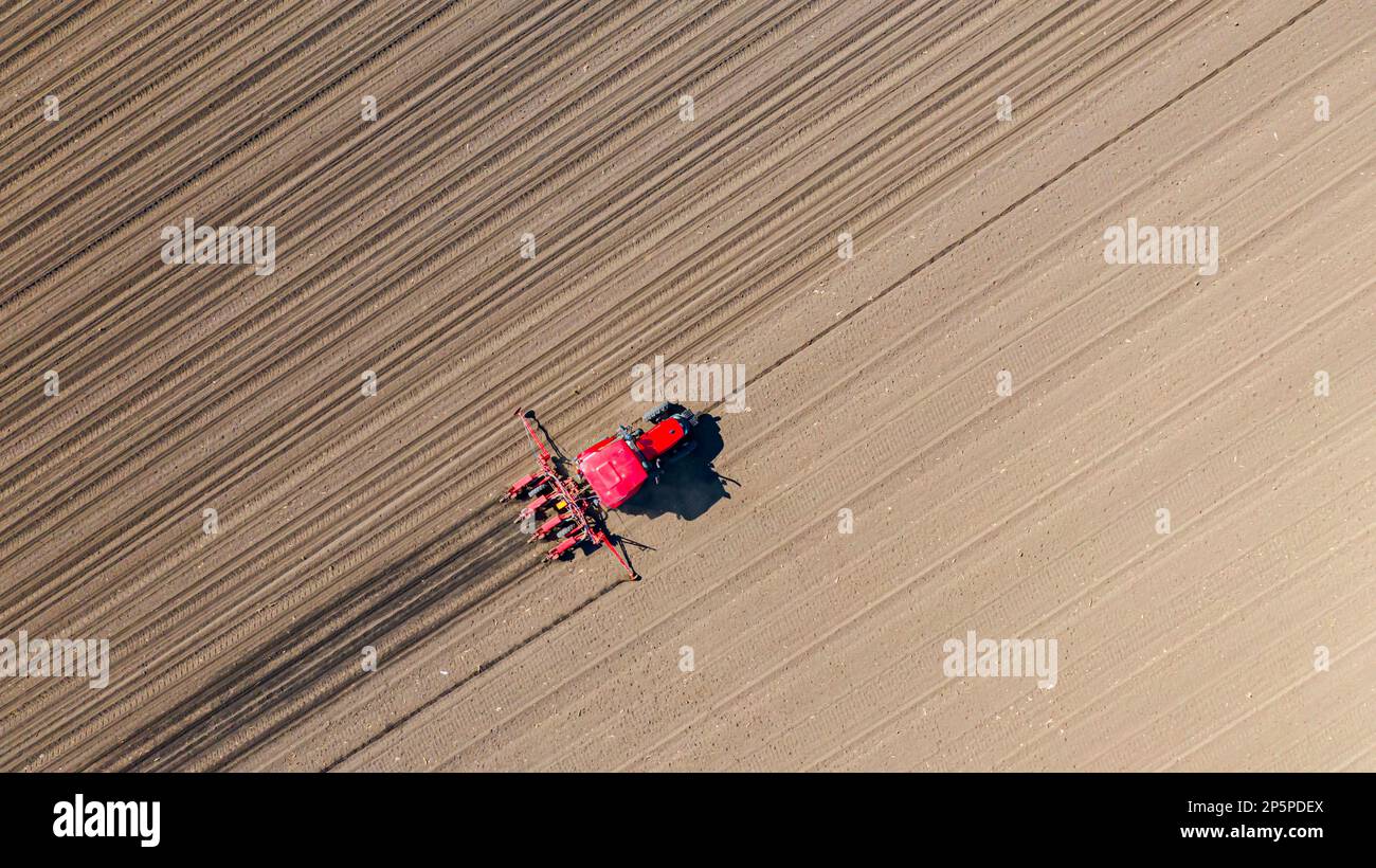 Above top view, of tractor as pulling mechanical seeder machine over ...