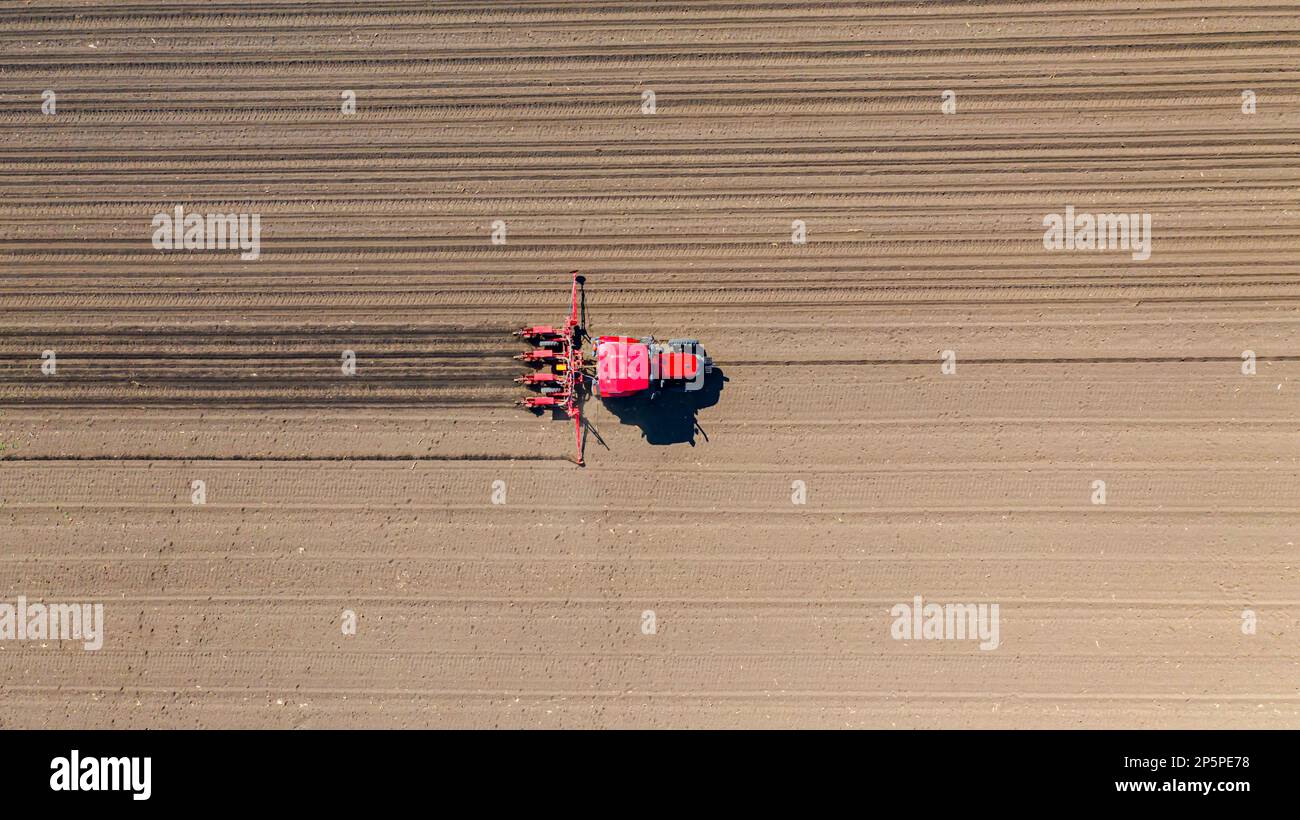 Above top view, of tractor as pulling mechanical seeder machine over ...