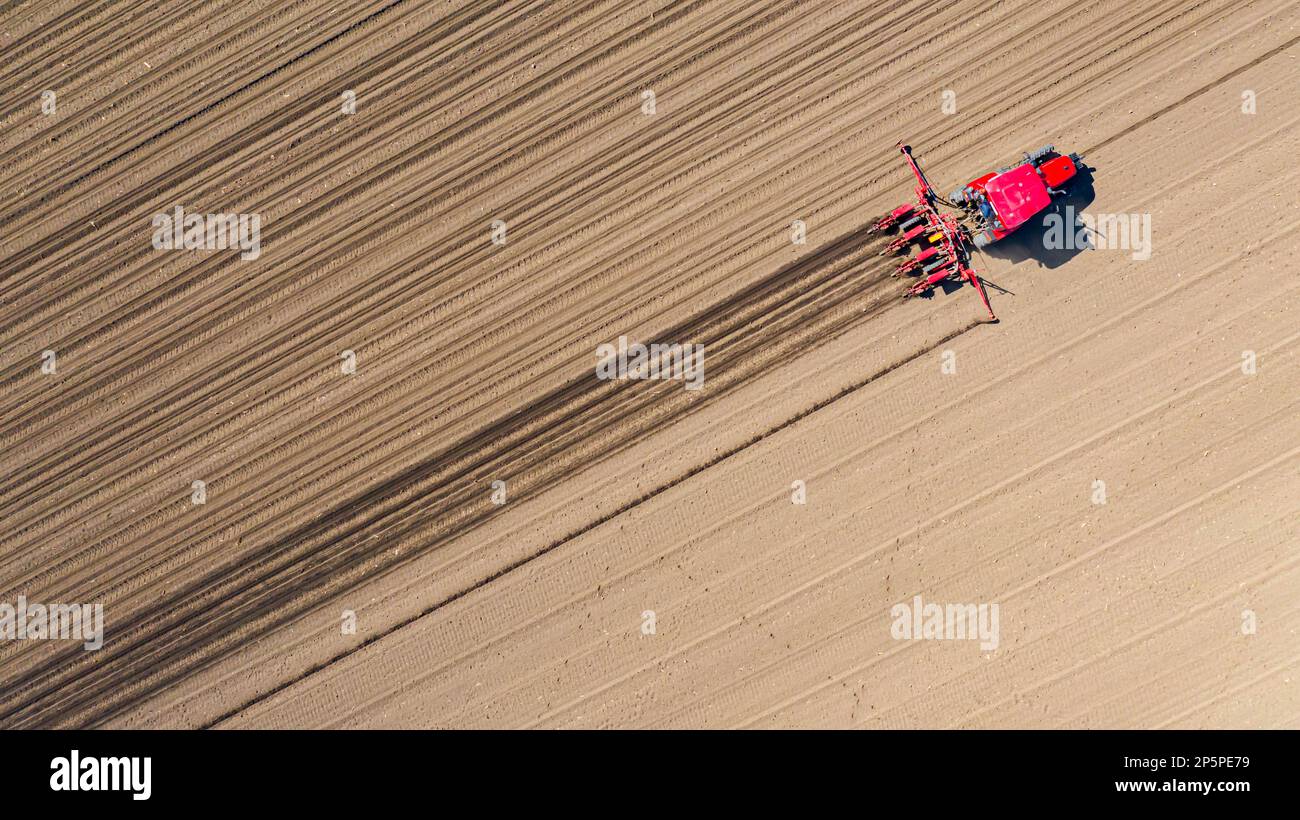 Above top view, of tractor as pulling mechanical seeder machine over ...
