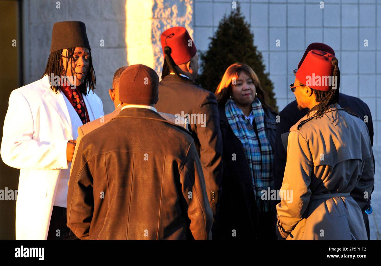 Minister Craig Fuqua-Bey , left, chats with mourners outside the ...