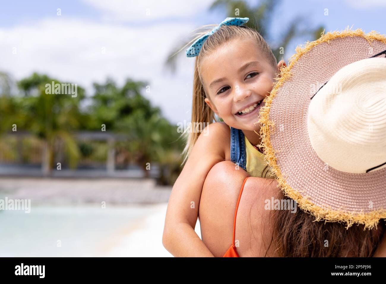 Happy Biracial Mother And Daughter Embracing By The Swimming Pool Stock