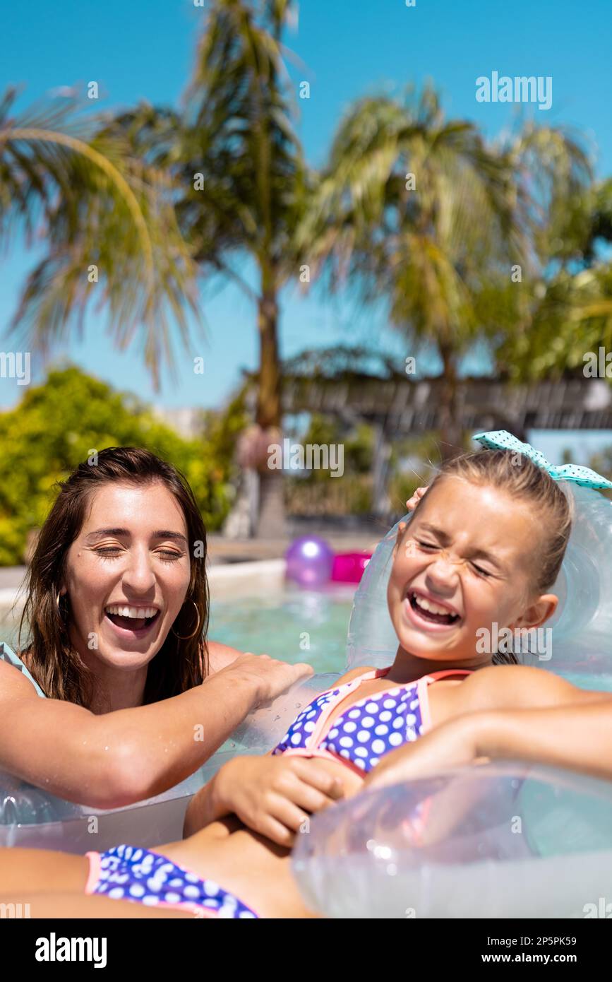 Happy Biracial Mother And Daughter And Son Playing Together In Swimming