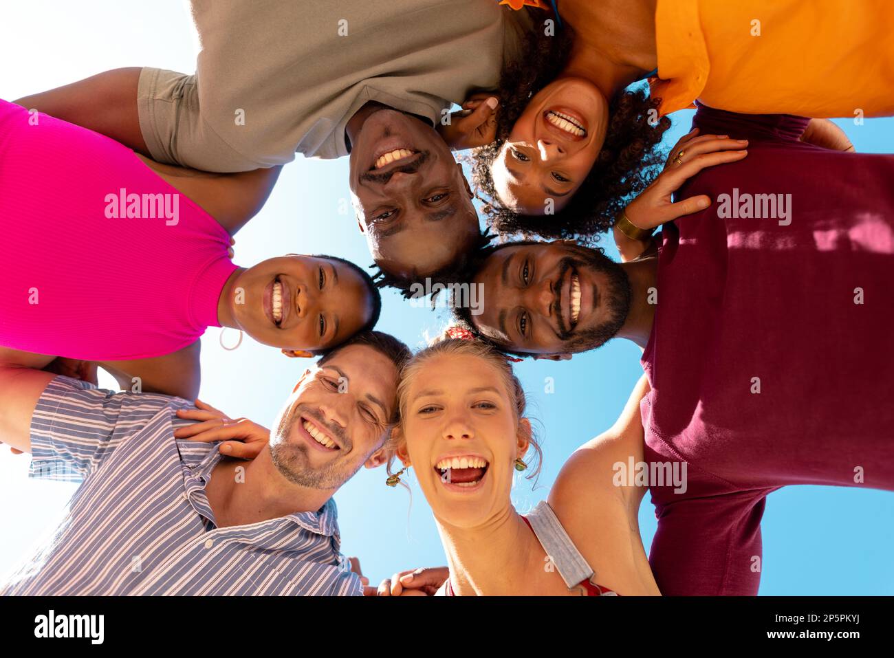 Portrait of happy diverse friends embracing and smiling at beach, with ...