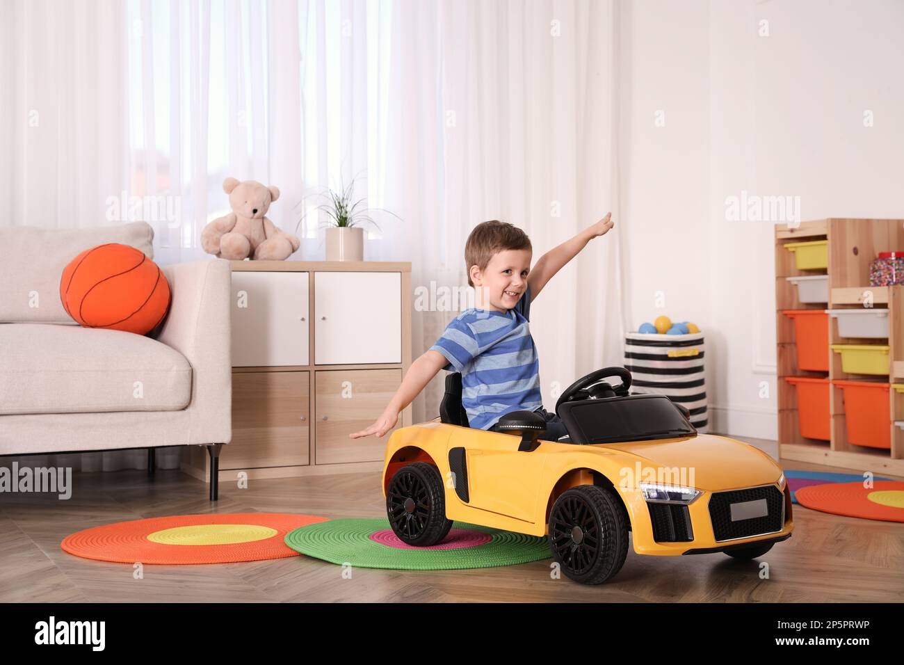 Little child playing with toy car in room Stock Photo - Alamy