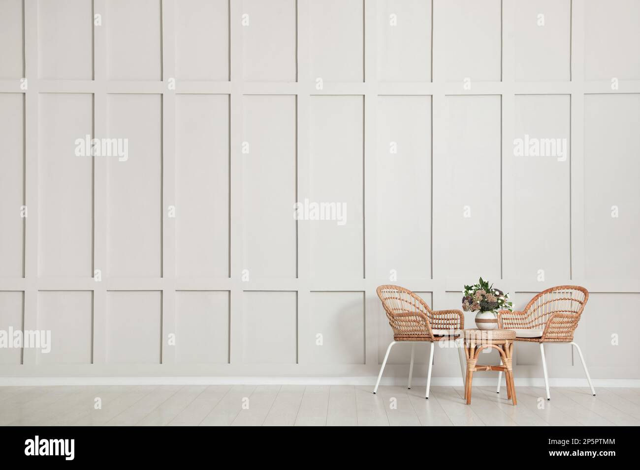 Simple room interior with set of wicker furniture, beautiful flowers ...