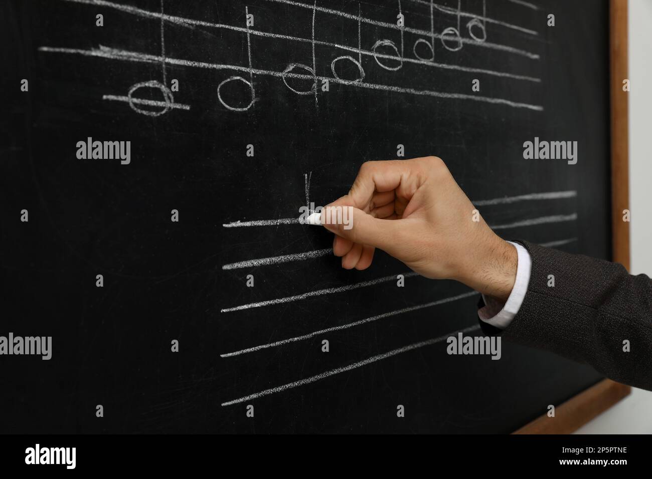 Teacher writing music notes with chalk on blackboard, closeup Stock ...