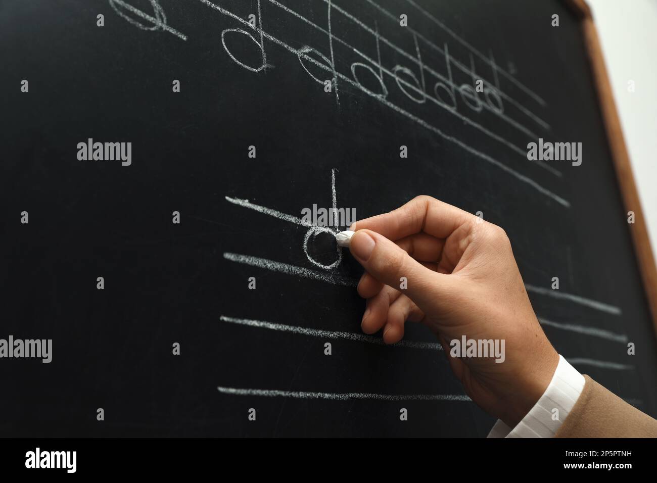 Teacher writing music notes with chalk on blackboard, closeup Stock ...