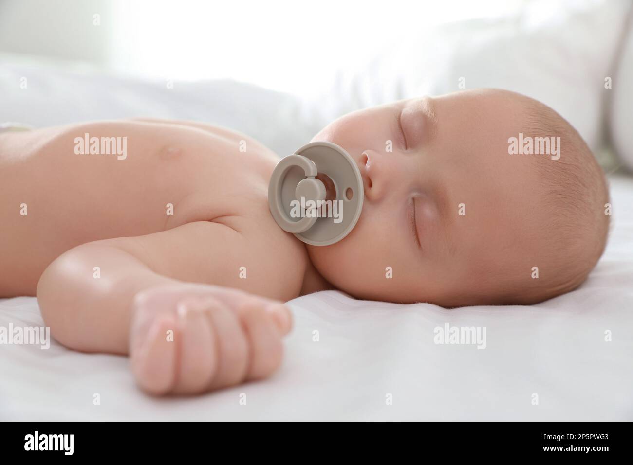 Cute little baby with pacifier sleeping on bed, closeup Stock Photo - Alamy