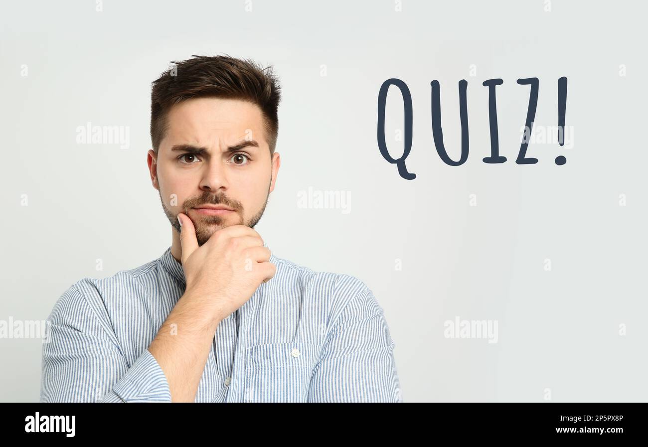 Thoughtful man and word QUIZ on white background Stock Photo - Alamy