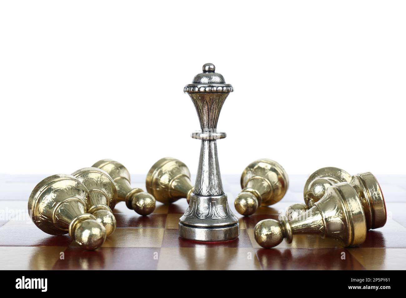 Silver queen among fallen golden pawns on wooden chess board against ...