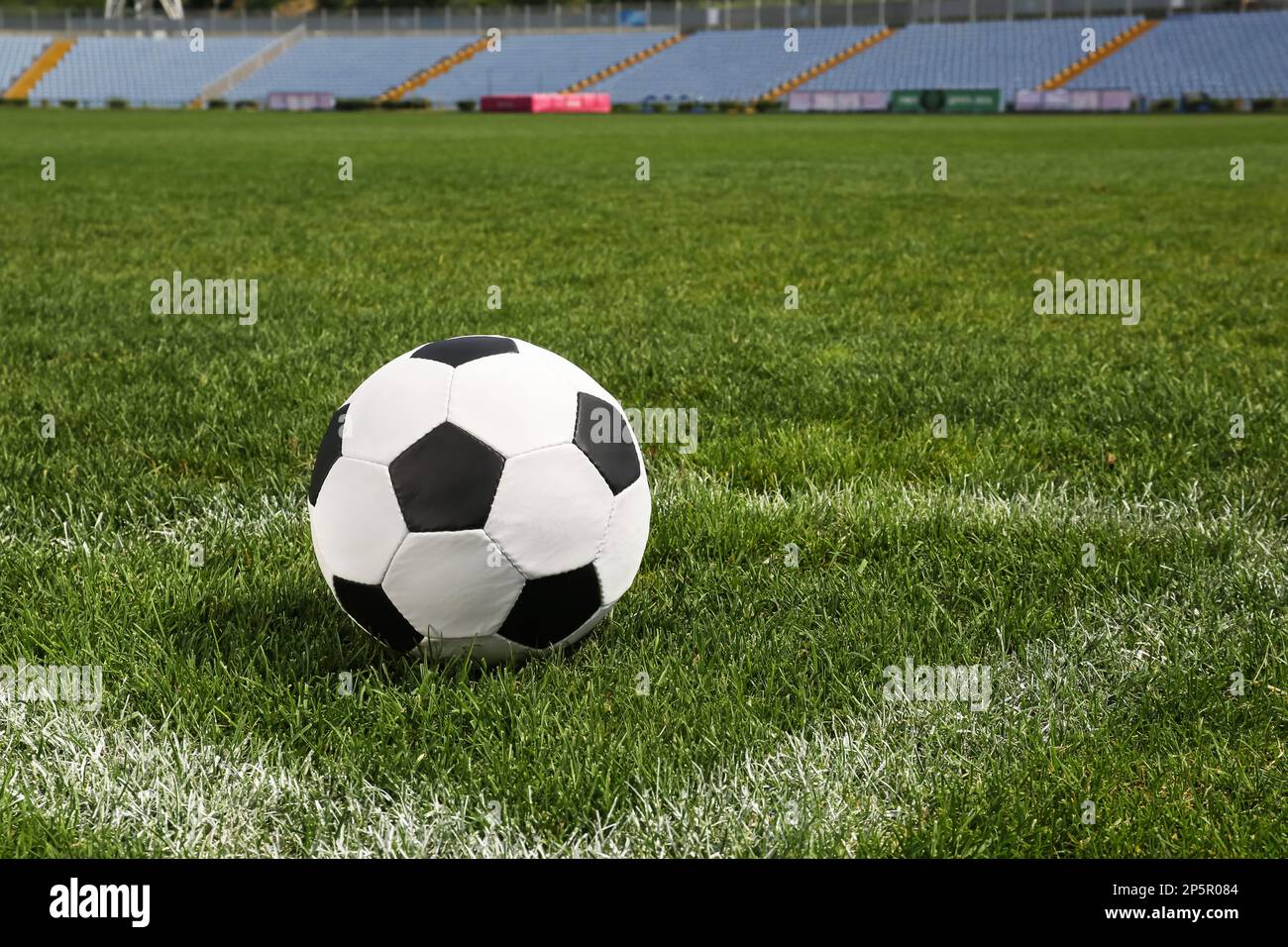 Football ball on green field grass in stadium Stock Photo - Alamy