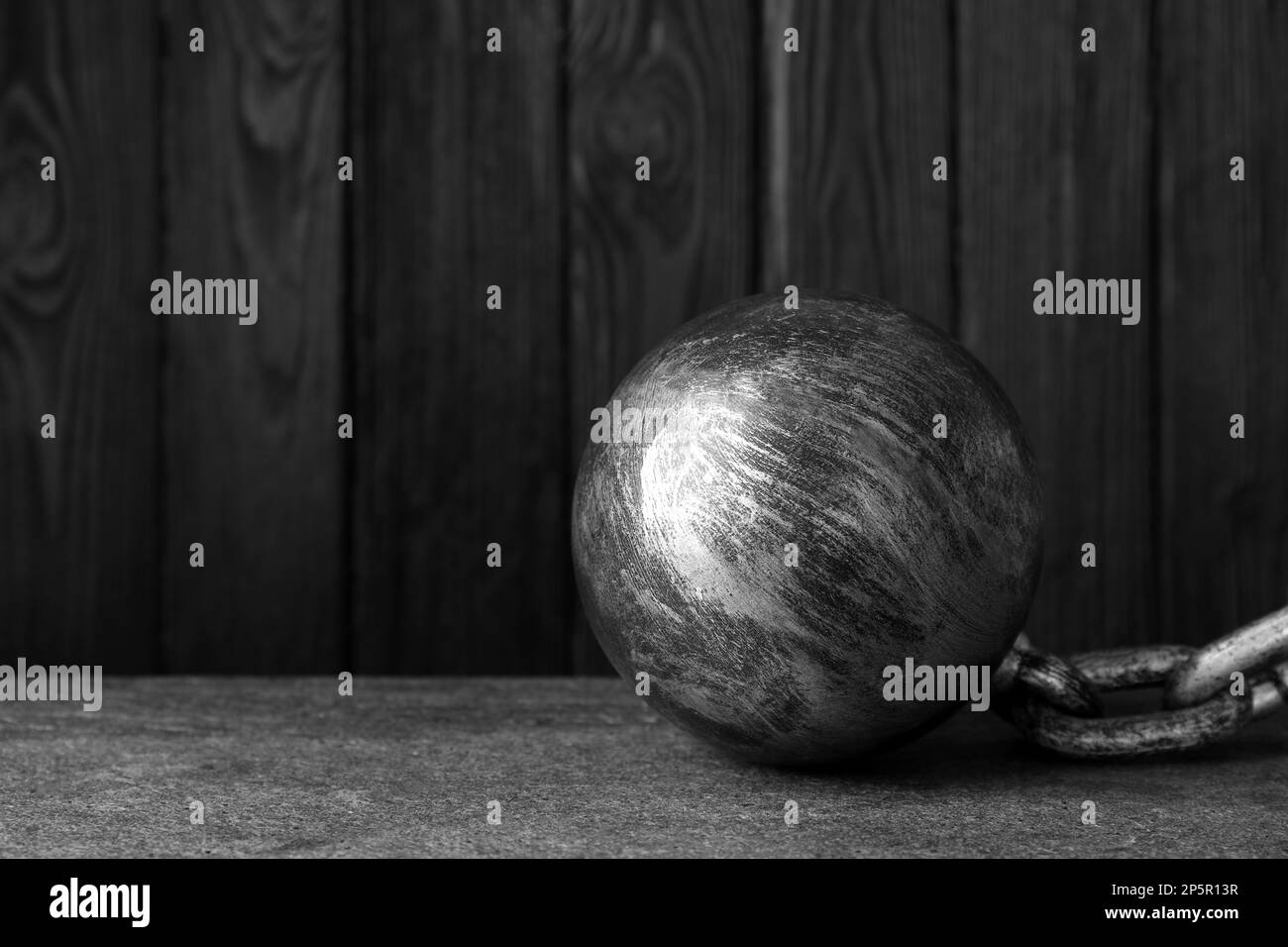 Prisoner ball with chain on grey table, space for text Stock Photo - Alamy