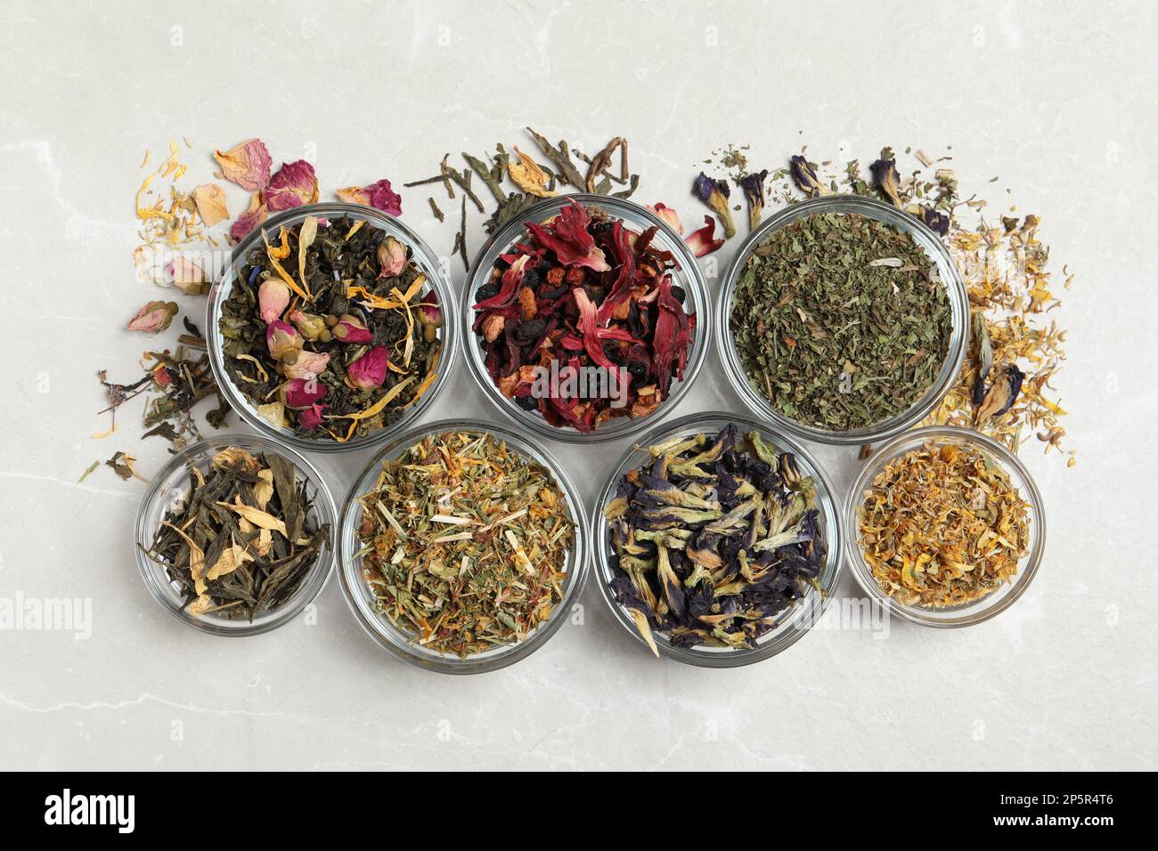 Flat lay composition with different dry teas on light table Stock Photo ...