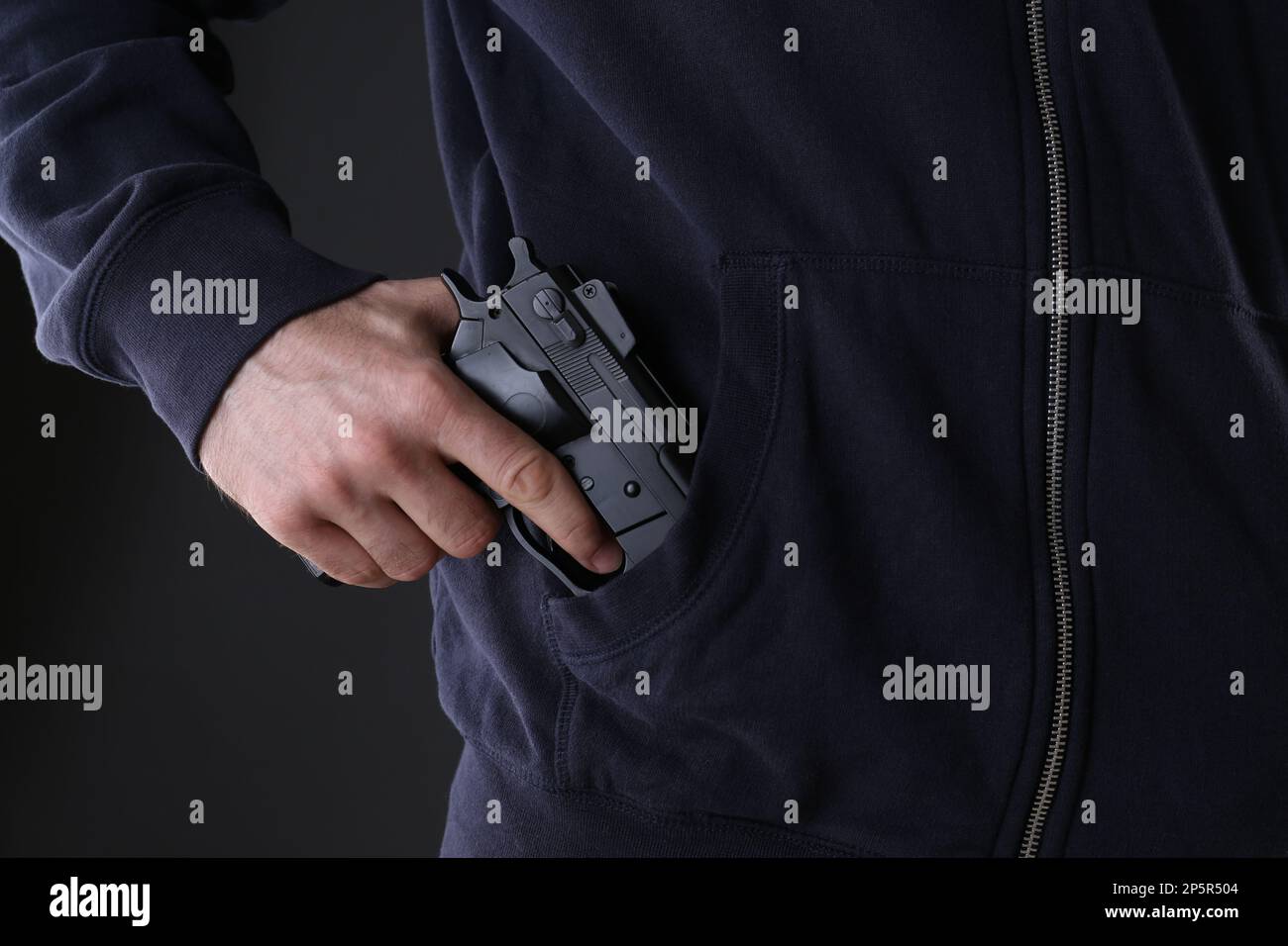 Man holding gun on black background, closeup Stock Photo - Alamy