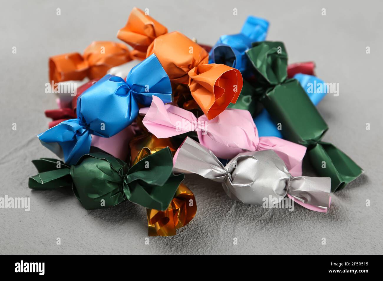 Candies in colorful wrappers on grey table Stock Photo - Alamy