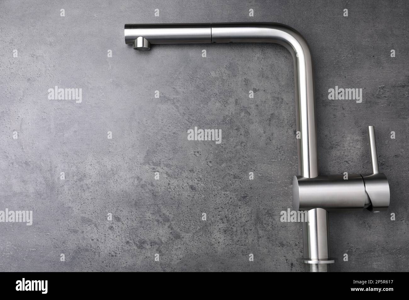 Modern pull out kitchen faucet on grey table, top view. Space for text ...