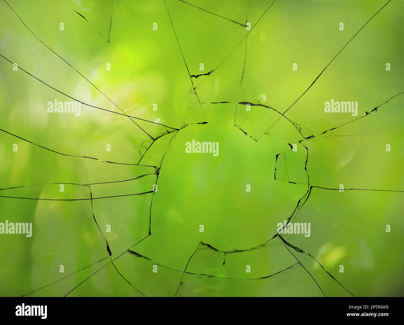 View through broken window on blurred green background Stock Photo - Alamy