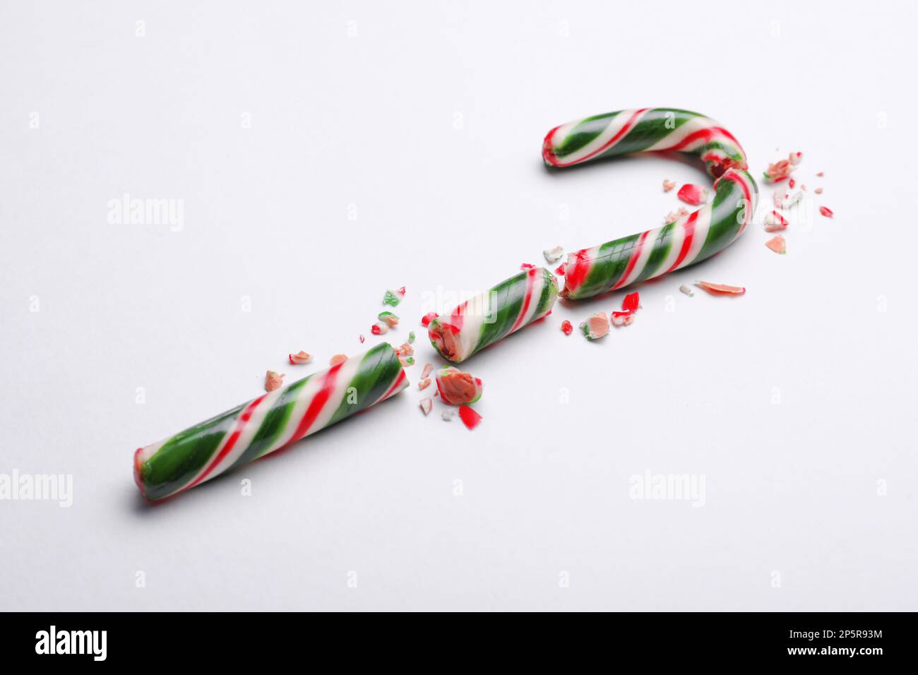 Broken sweet Christmas candy cane on white background Stock Photo - Alamy