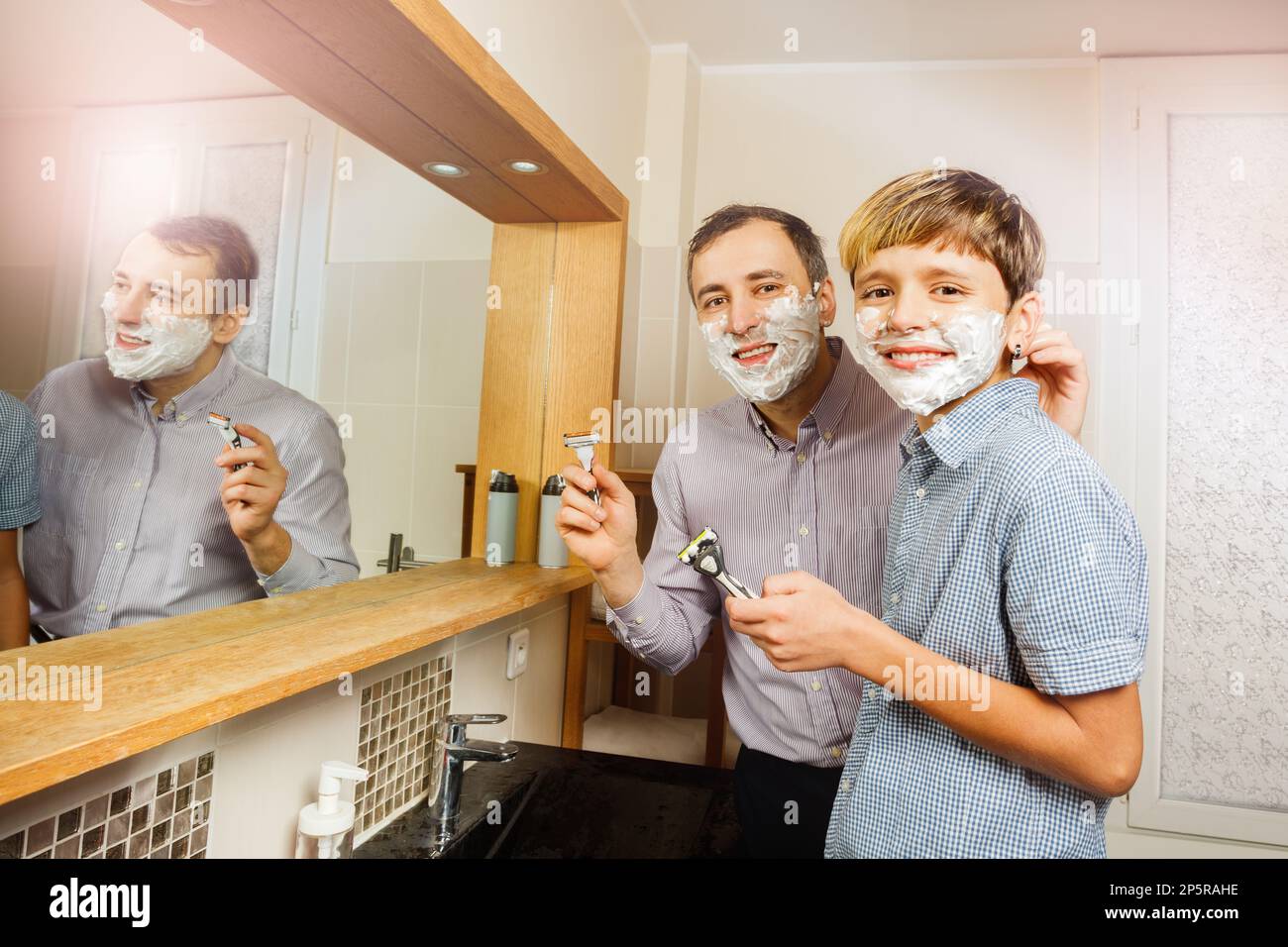 Father with kid shaving together holding razor in bathroom Stock Photo ...