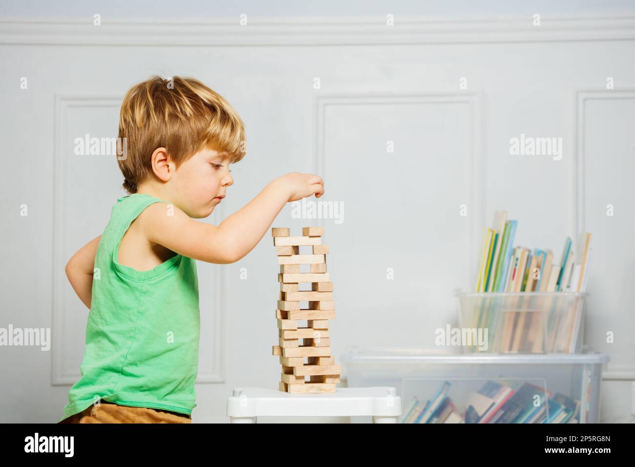 Child building a tower with books hi-res stock photography and images ...