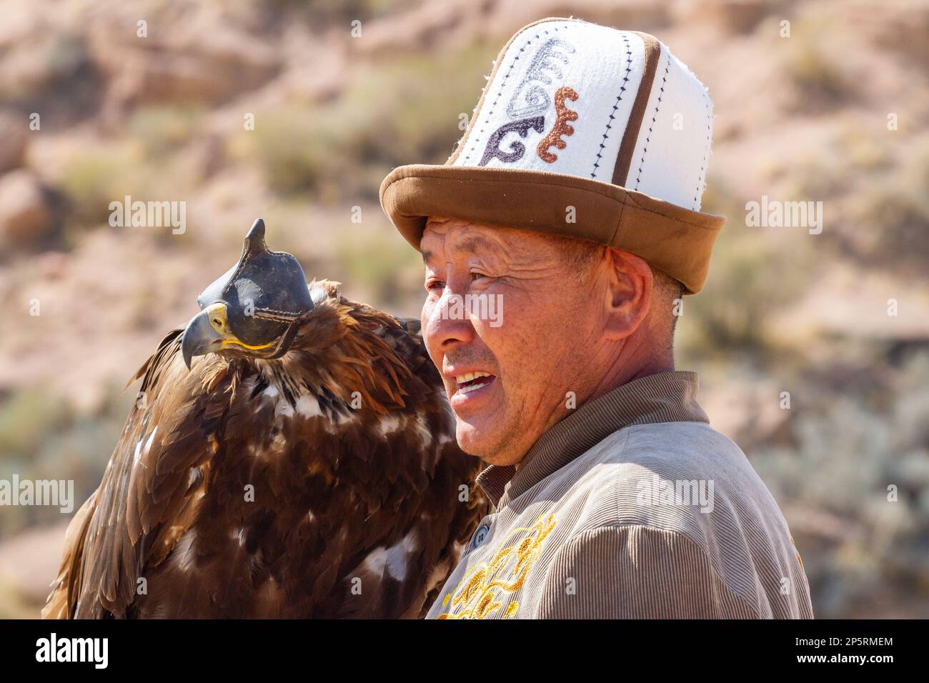 Kyrgyz hunter or Berkutchi hugging a golden eagle, Kyrgyzstan Stock ...