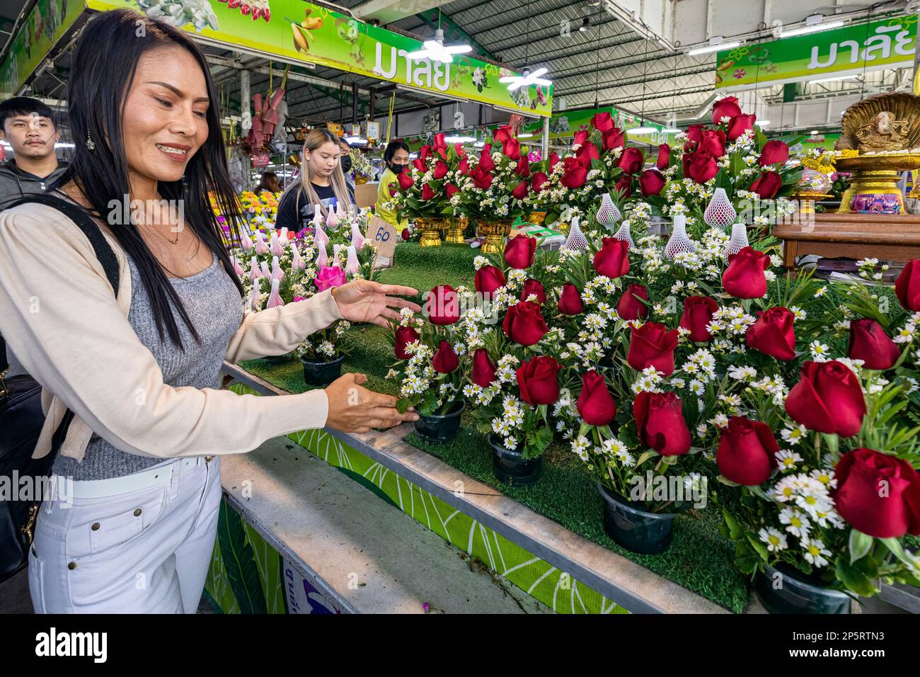 Thai lady customer inspecting flowers at Pak Khlong Talat Mai Flower ...