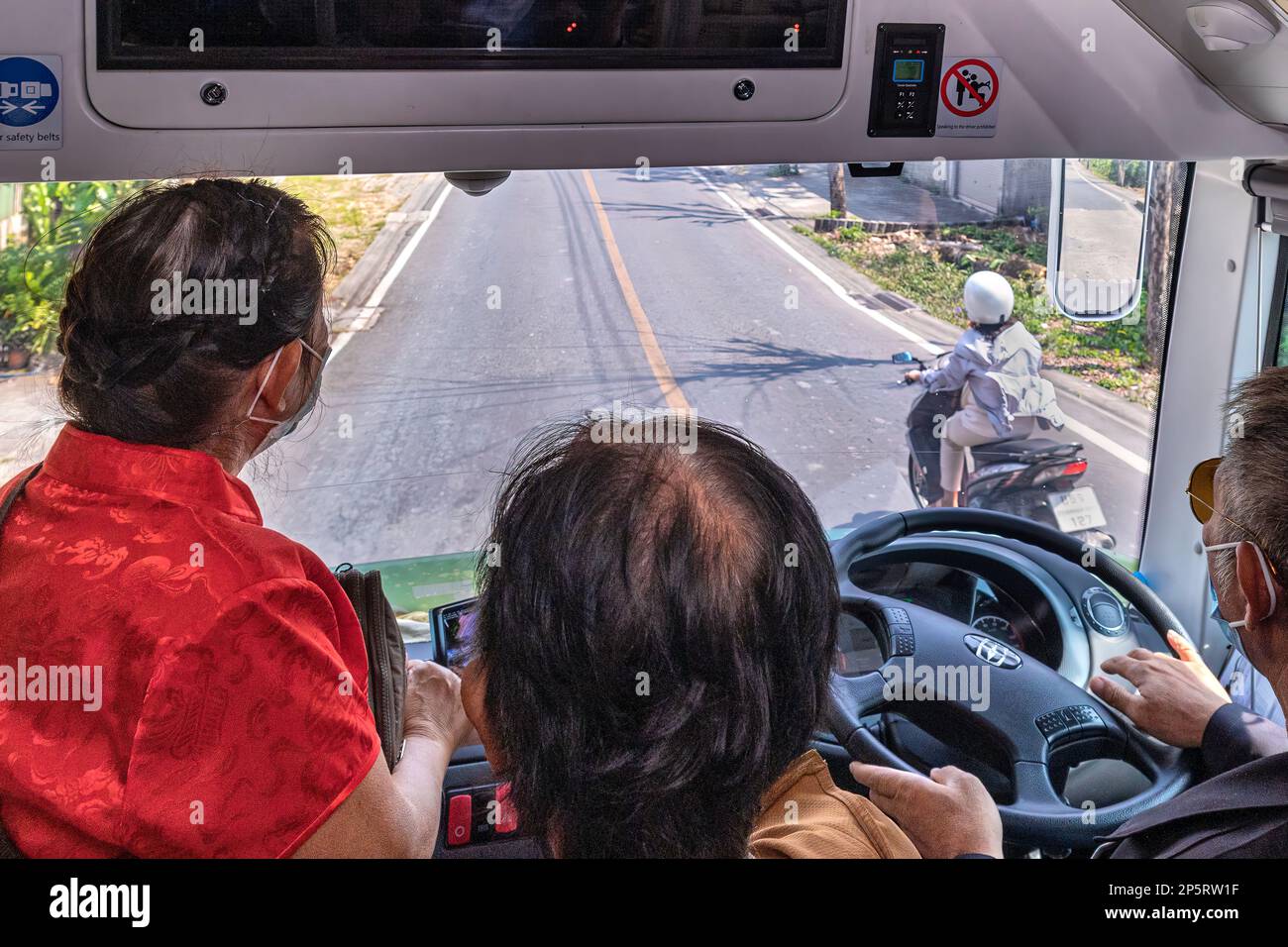 Driver and passengers looking through windscreen on electric shuttle ...