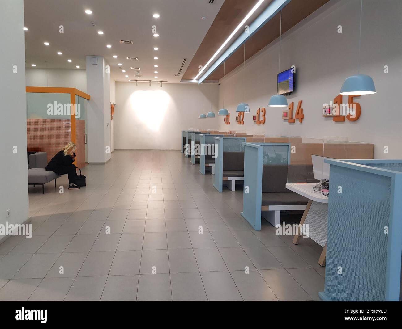 Woman waiting alone in bank countier Stock Photo - Alamy