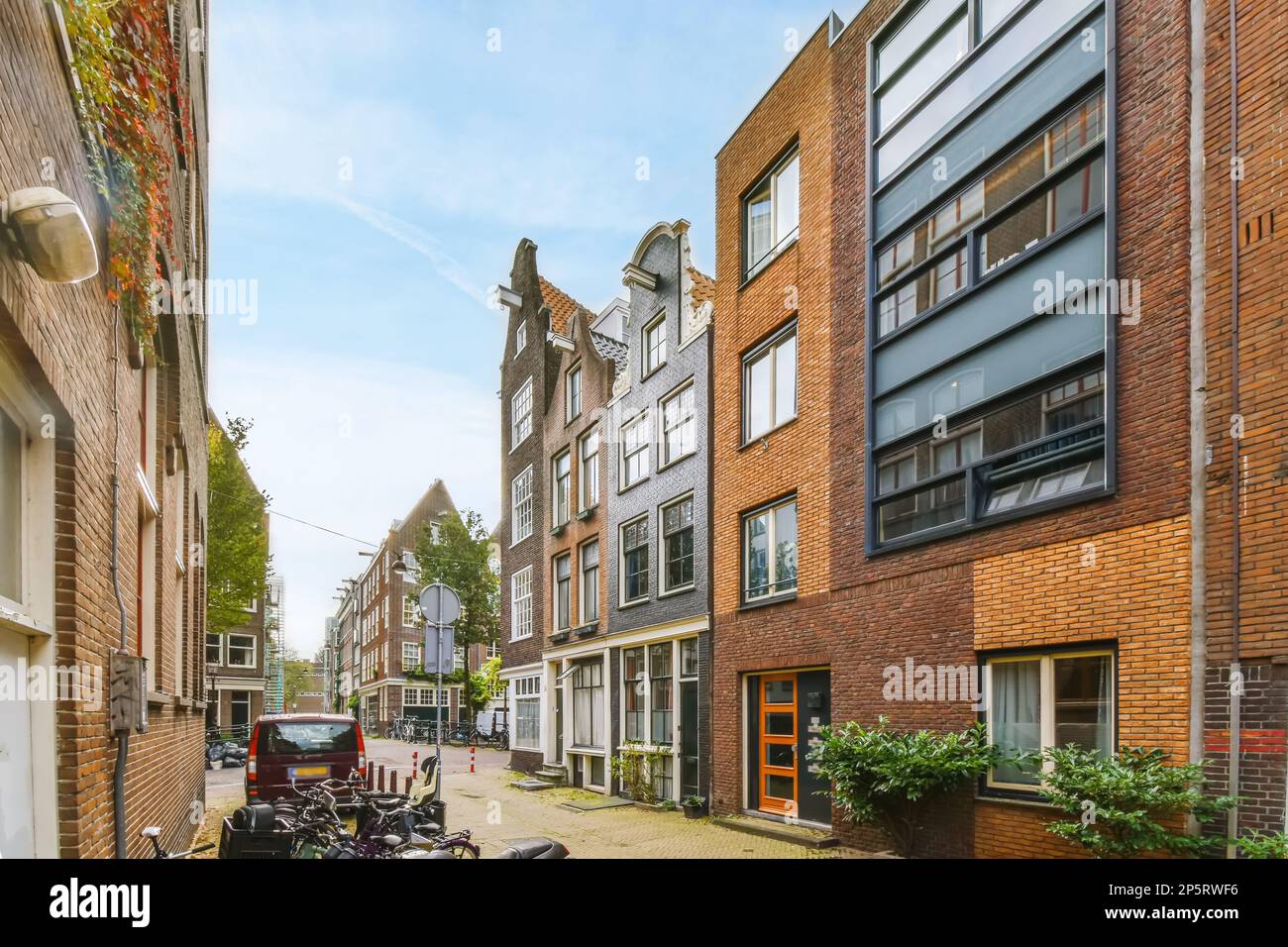 an urban street in the netherlands with bikes parked on the side and ...